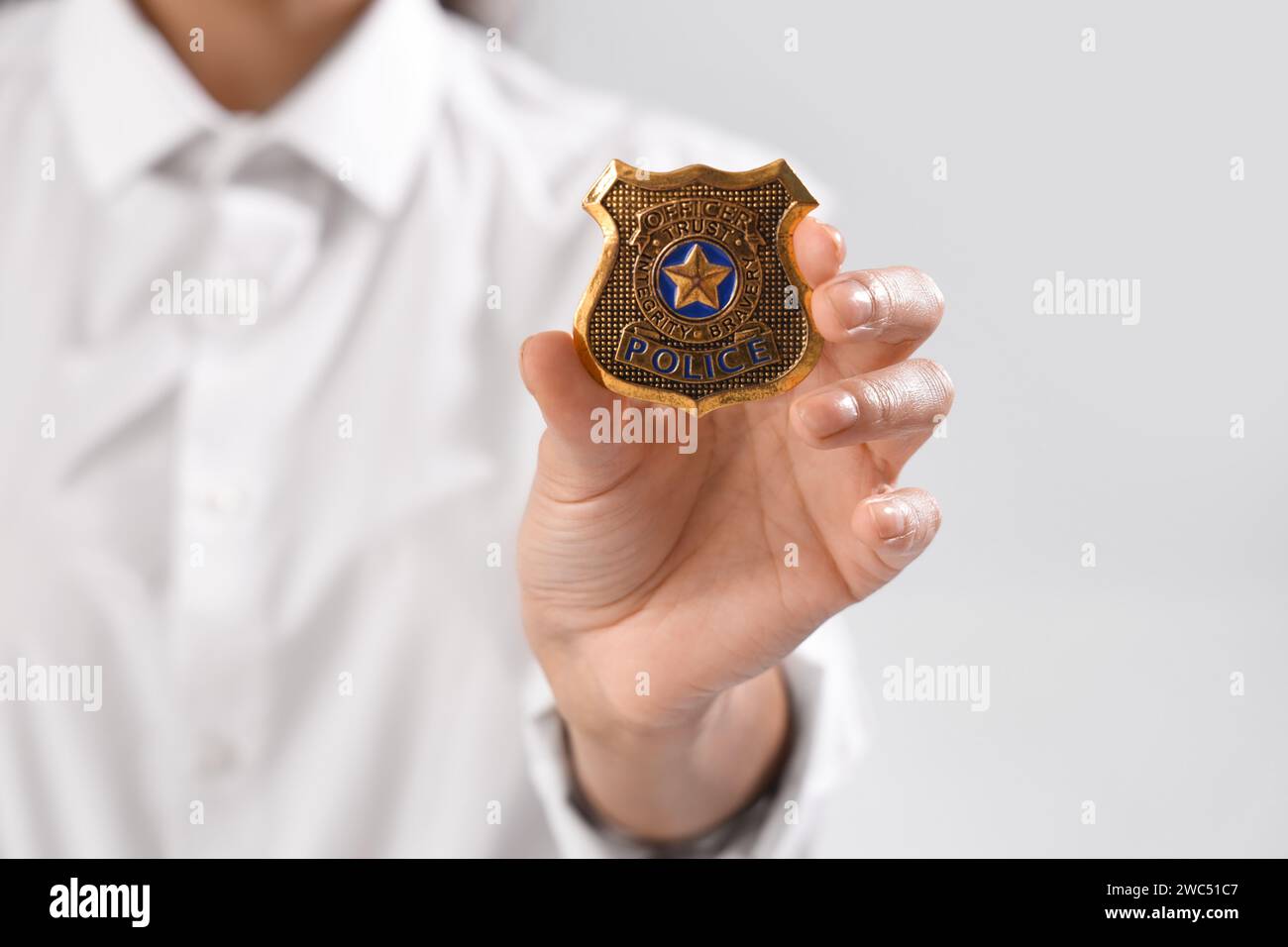 African-American female police officer with badge on white background ...