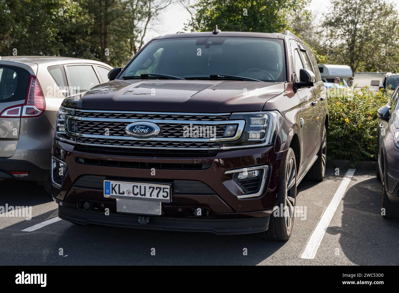 A front view of an imposing large maroon-brown fourth-generation Ford ...