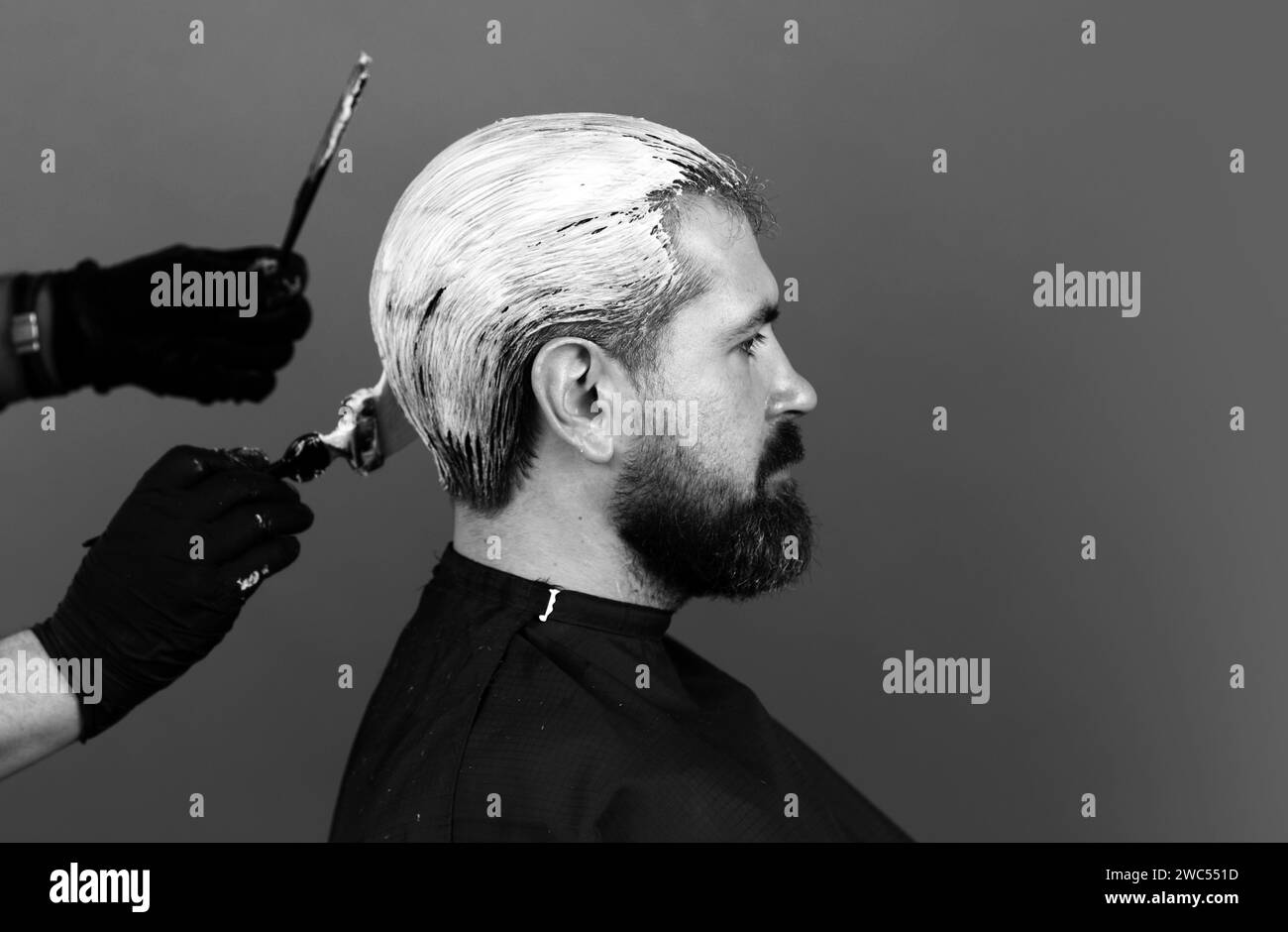 Bearded man color hair. Process of a man hair coloring at hairdresser ...