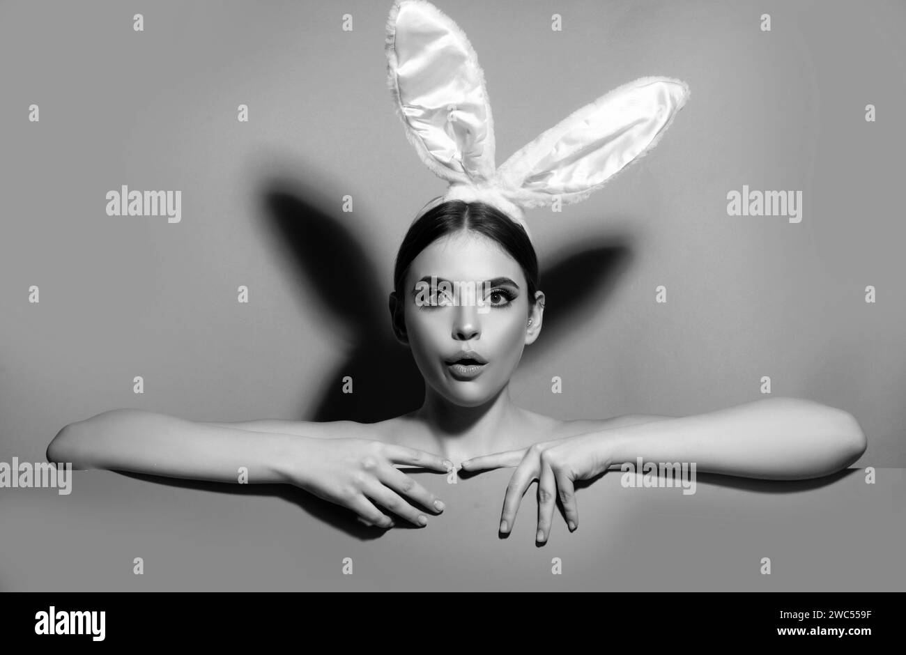 Easter bunny woman. Studio shot of a surprised young woman wearing ...