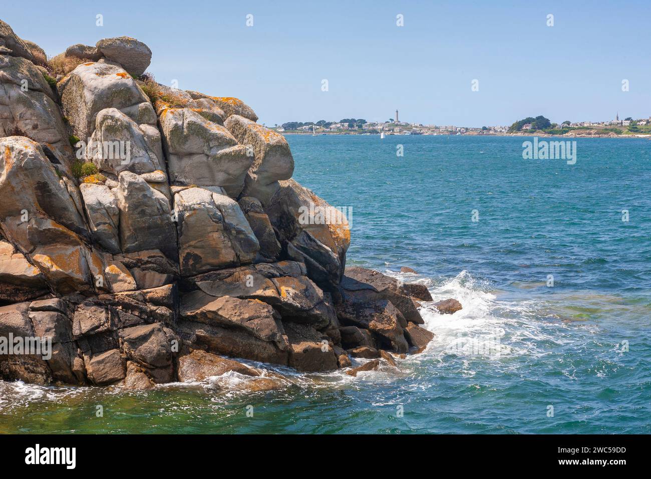 Half-tide rocks off the Old Port of Roscoff, with the Île de Batz in the distance: Finistère ...