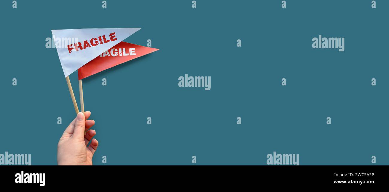 Small paper flags in hand with the warning 'Fragile' as a label. The ...