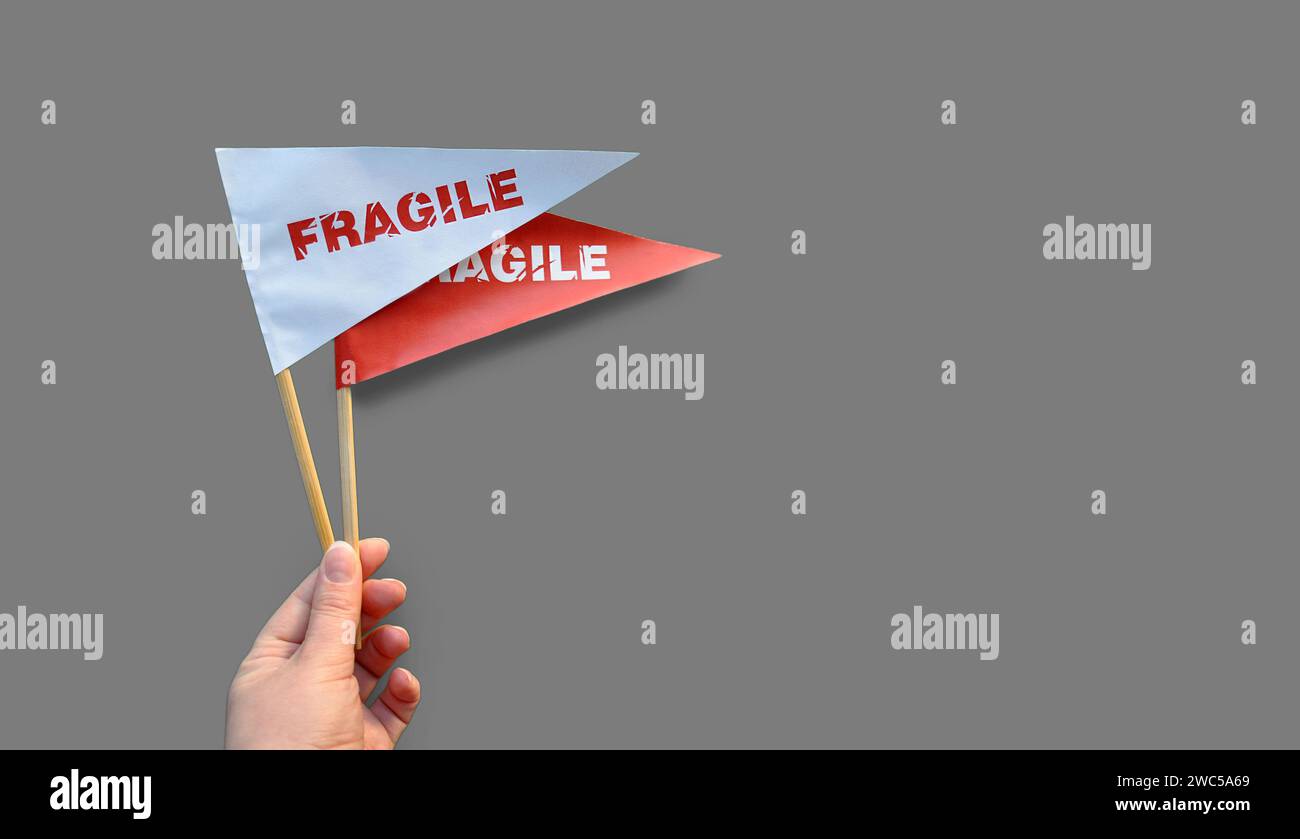Small paper flags in hand with the warning 'Fragile' as a label. The ...