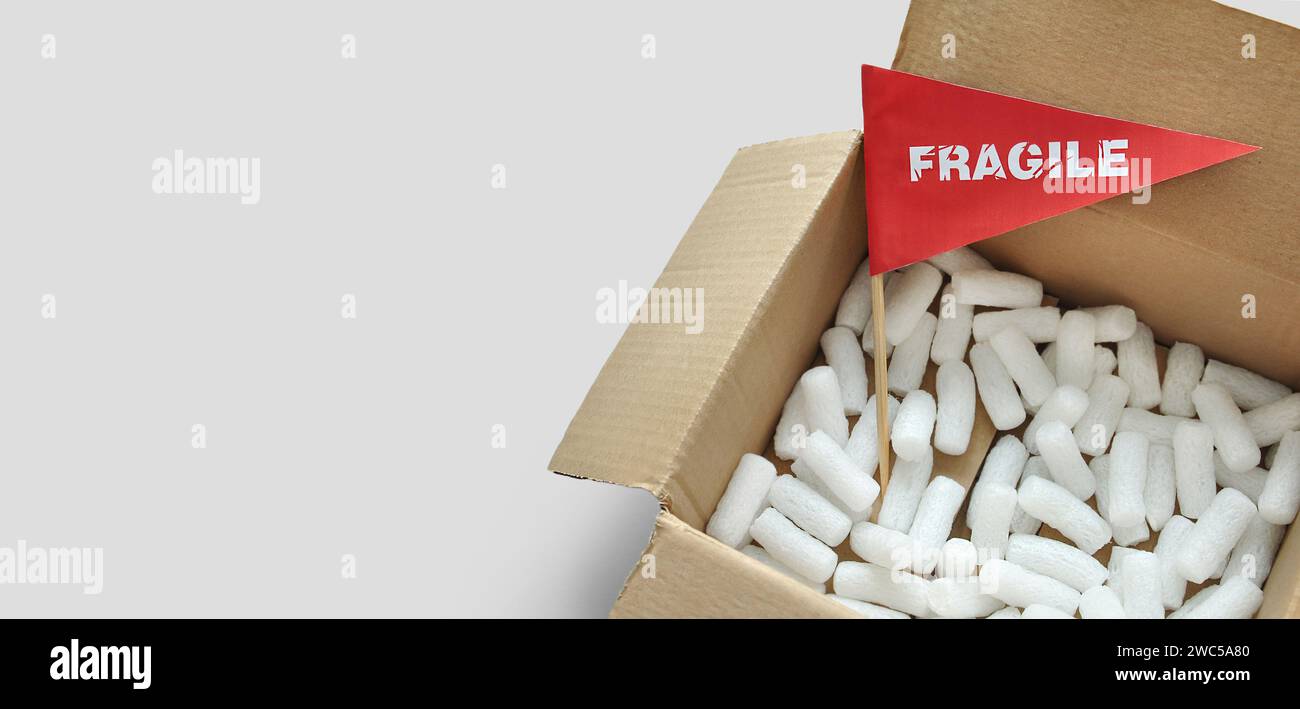 Opened cardboard packaging box with white polystyrene packing chips ...