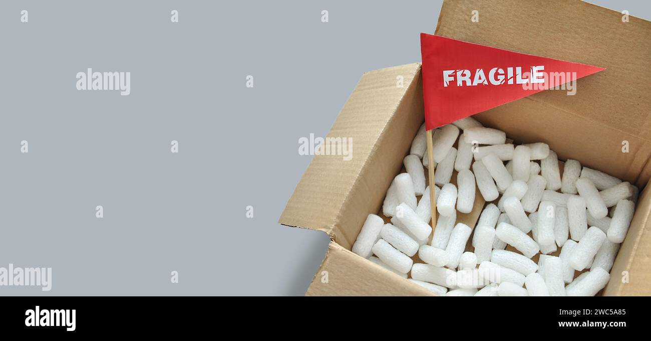 Opened cardboard packaging box with white polystyrene packing chips ...