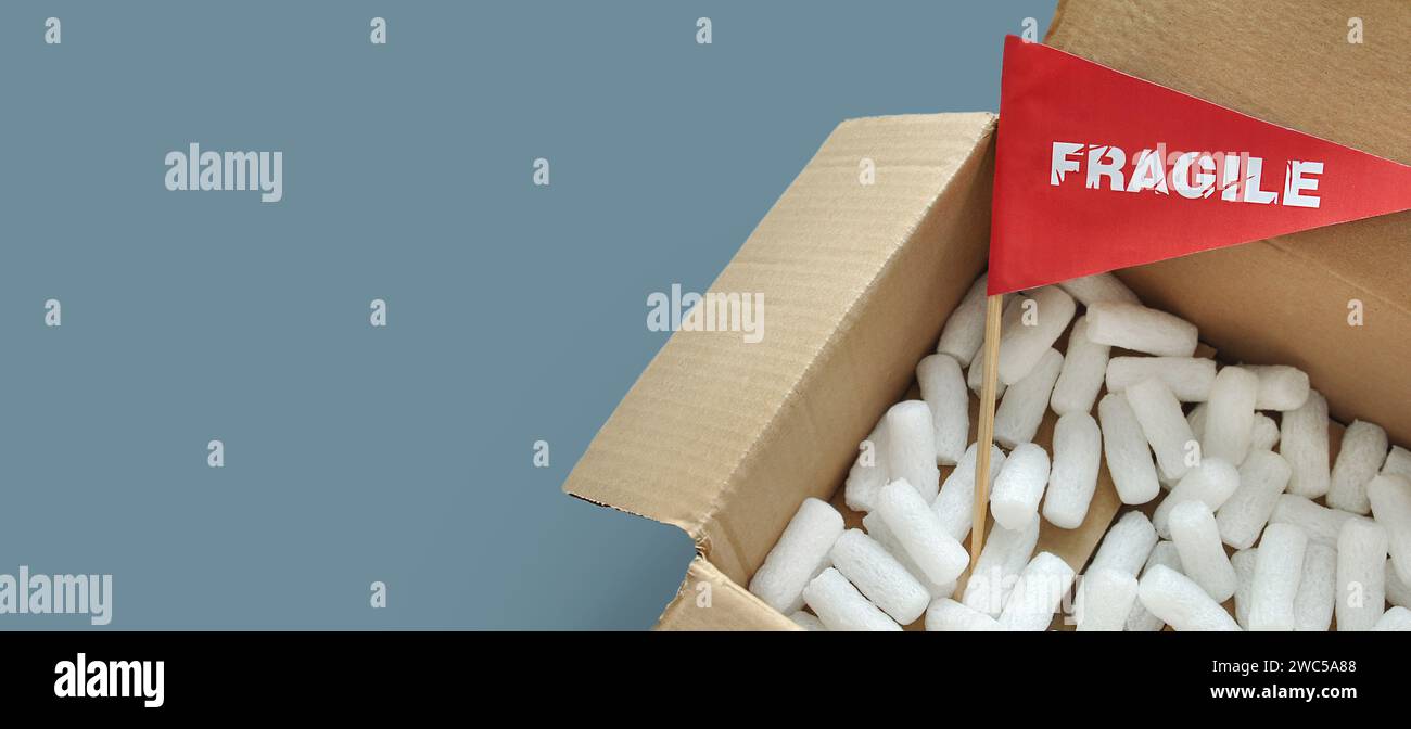 Opened cardboard packaging box with white polystyrene packing chips ...