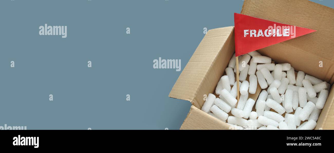 Opened cardboard packaging box with white polystyrene packing chips ...