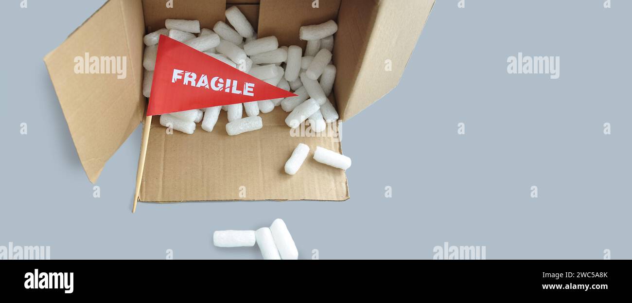 An overturned open cardboard packaging box with fallen white ...