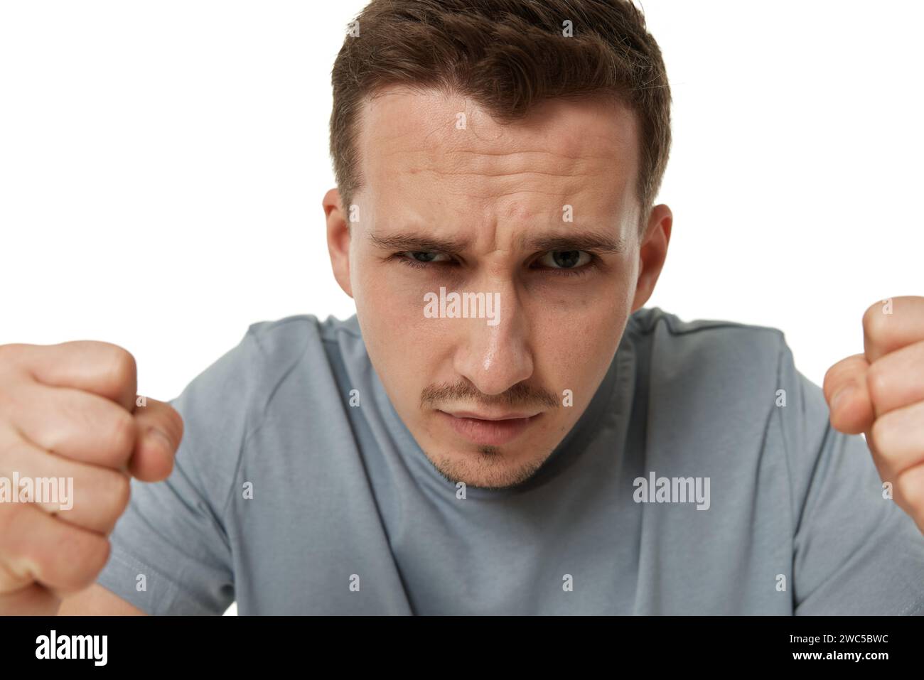angry guy looking at camera on white studio background Stock Photo - Alamy