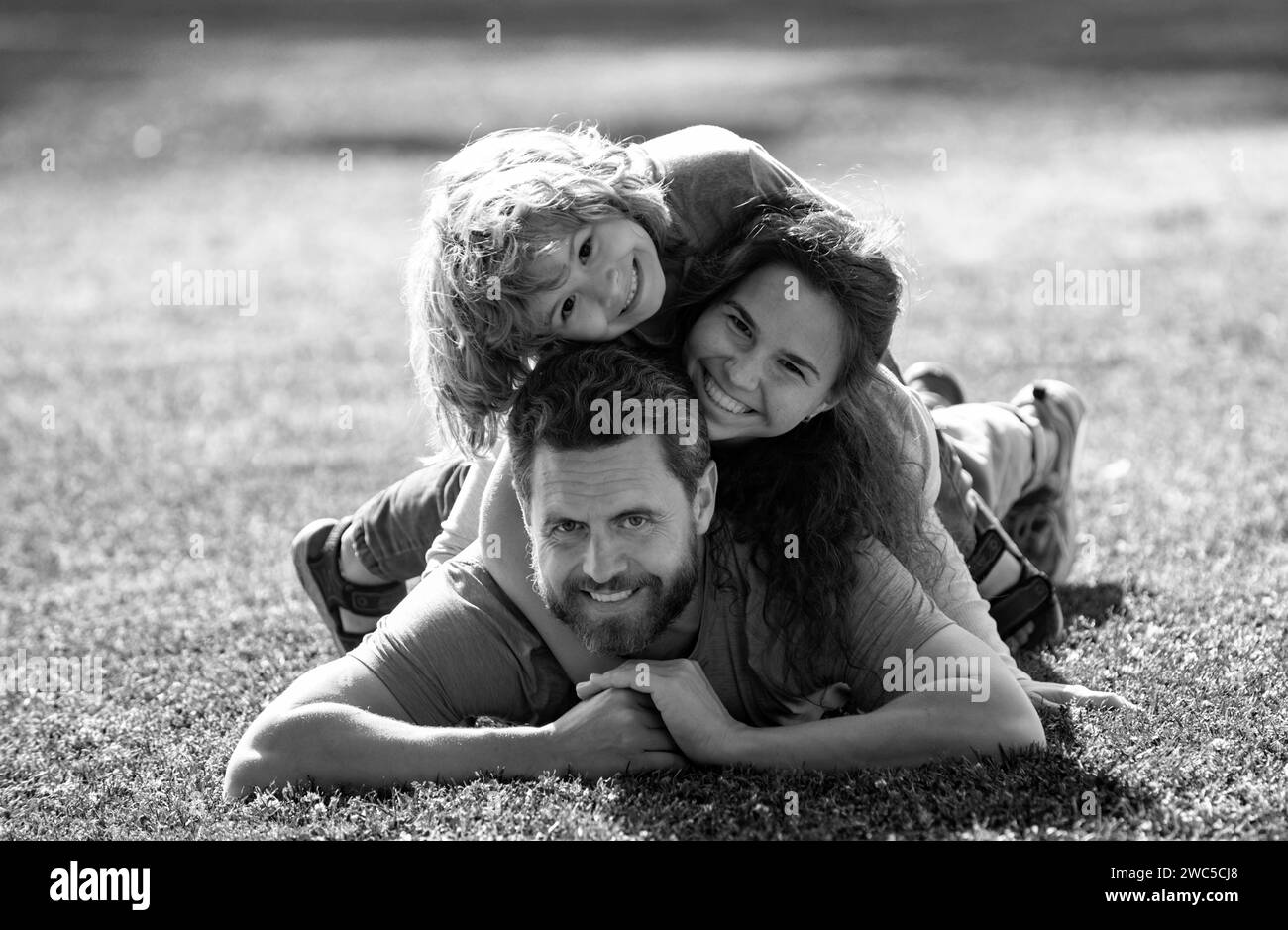 Family hugging and embracing on grass in park Stock Photo - Alamy