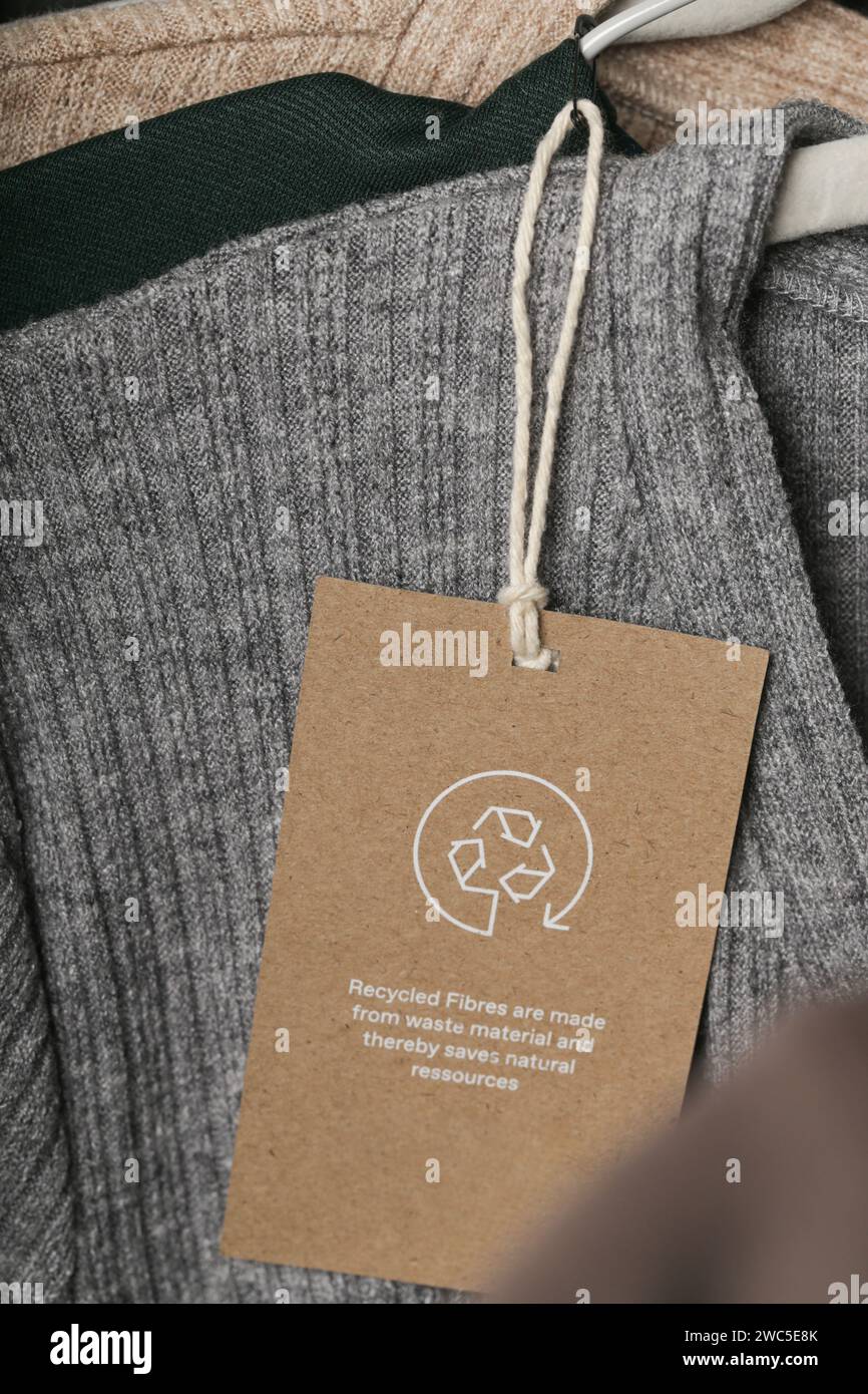 Close up of clothing tag with recycle icon. Recycling products concept ...