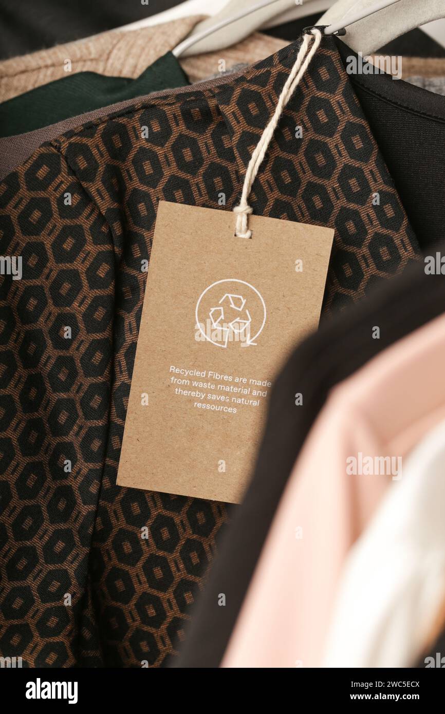Close up of clothing tag with recycle icon. Recycling products concept ...