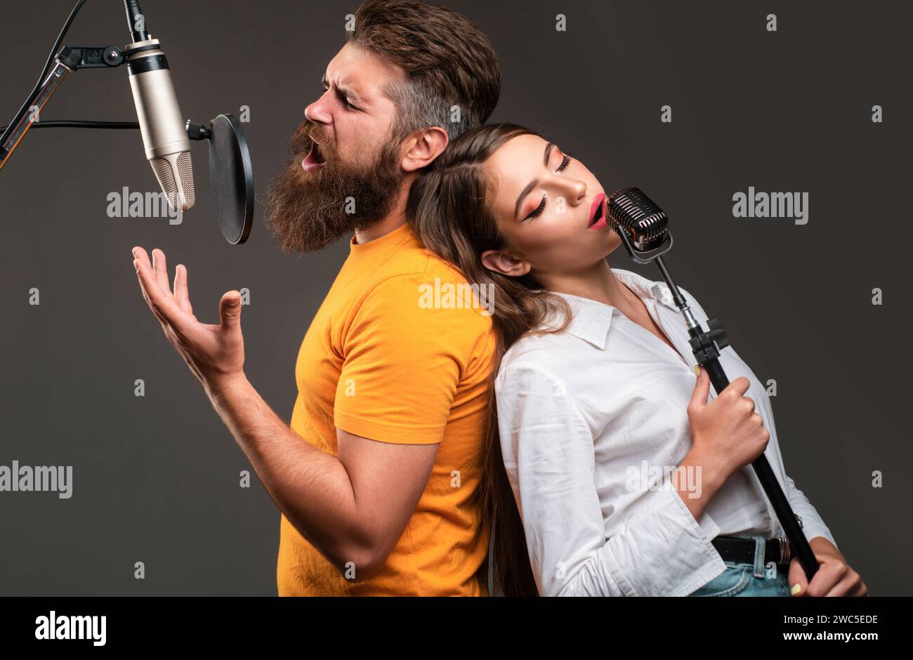 Couple duet with microphone singing song. Musician in music hall Stock ...