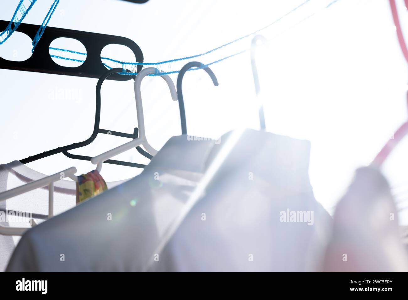 Drying clothes in the sun using a laundry rope that keeps clothes ...