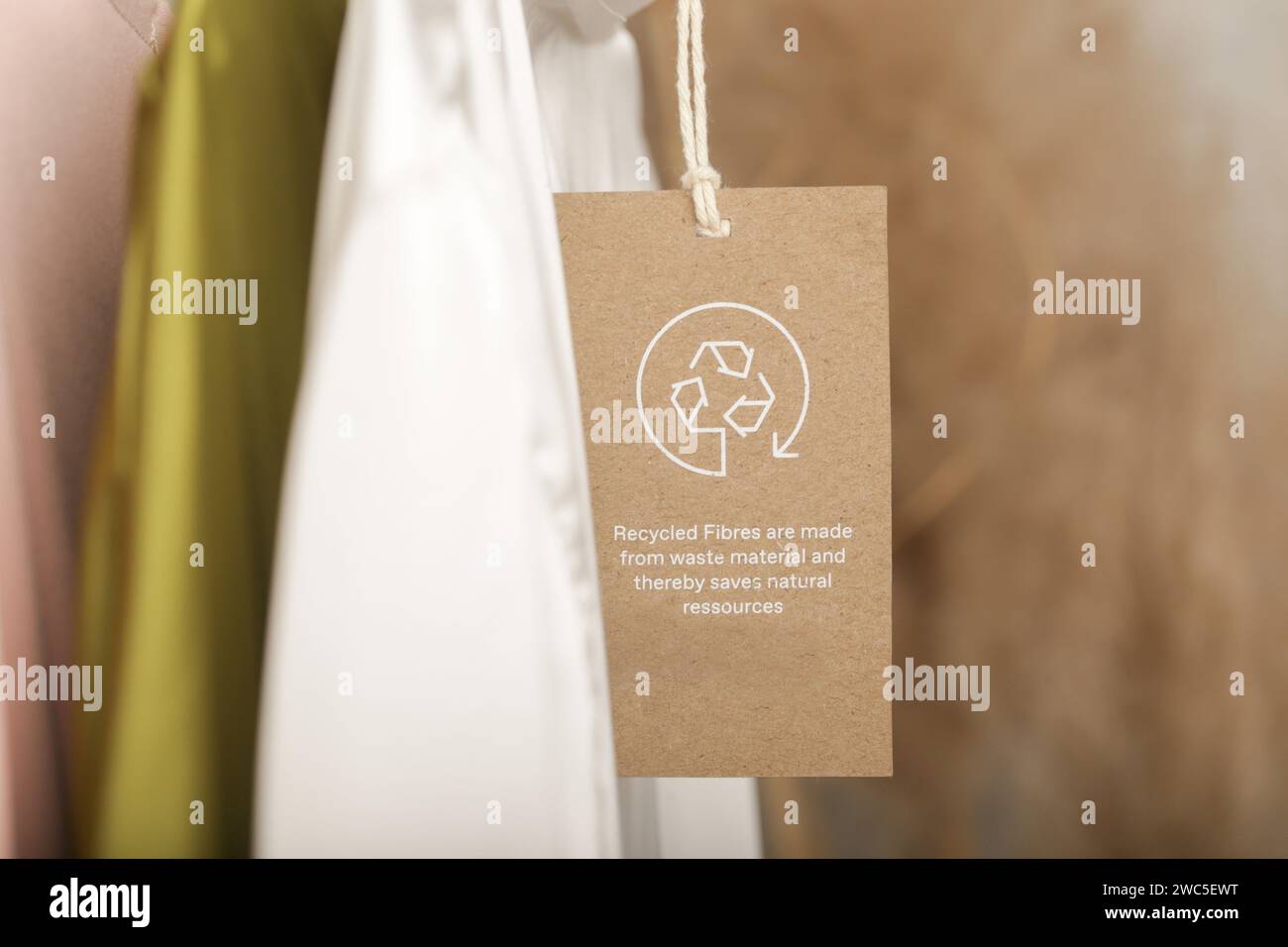 Close up of clothing tag with recycle icon. Recycling products concept ...
