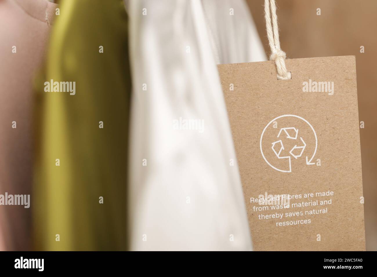 Close up of clothing tag with recycle icon. Recycling products concept ...