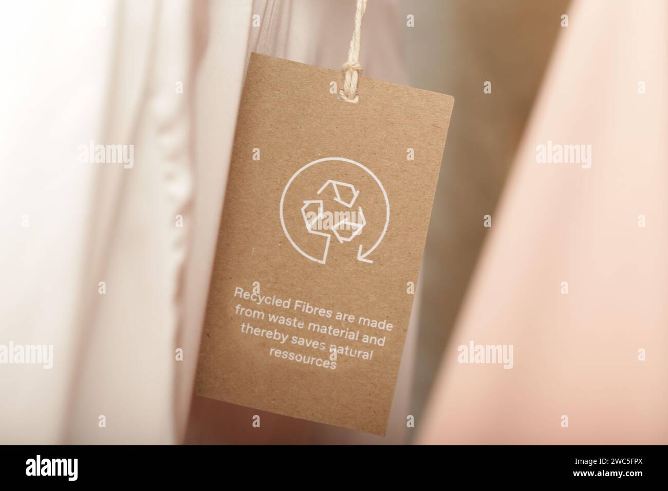 Close up of clothing tag with recycle icon. Recycling products concept ...