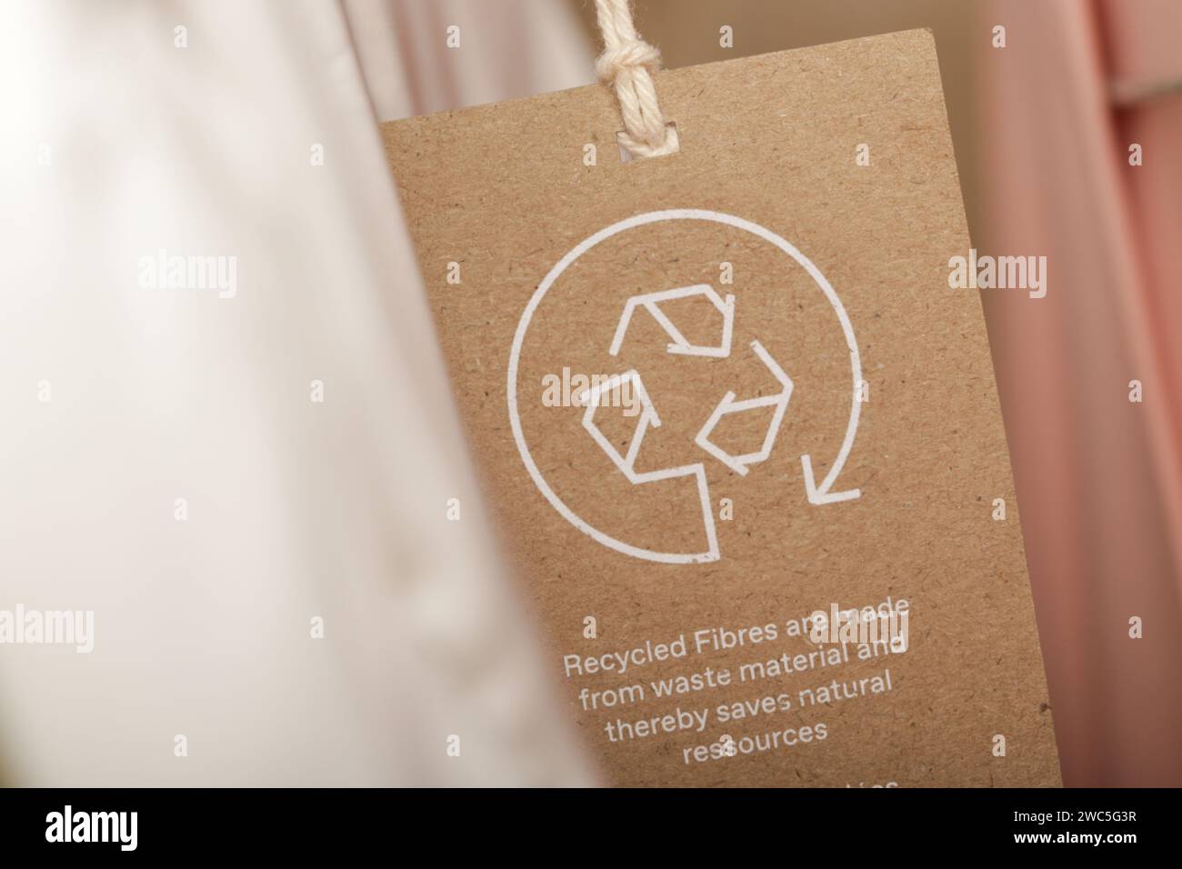Close up of clothing tag with recycle icon. Recycling products concept ...