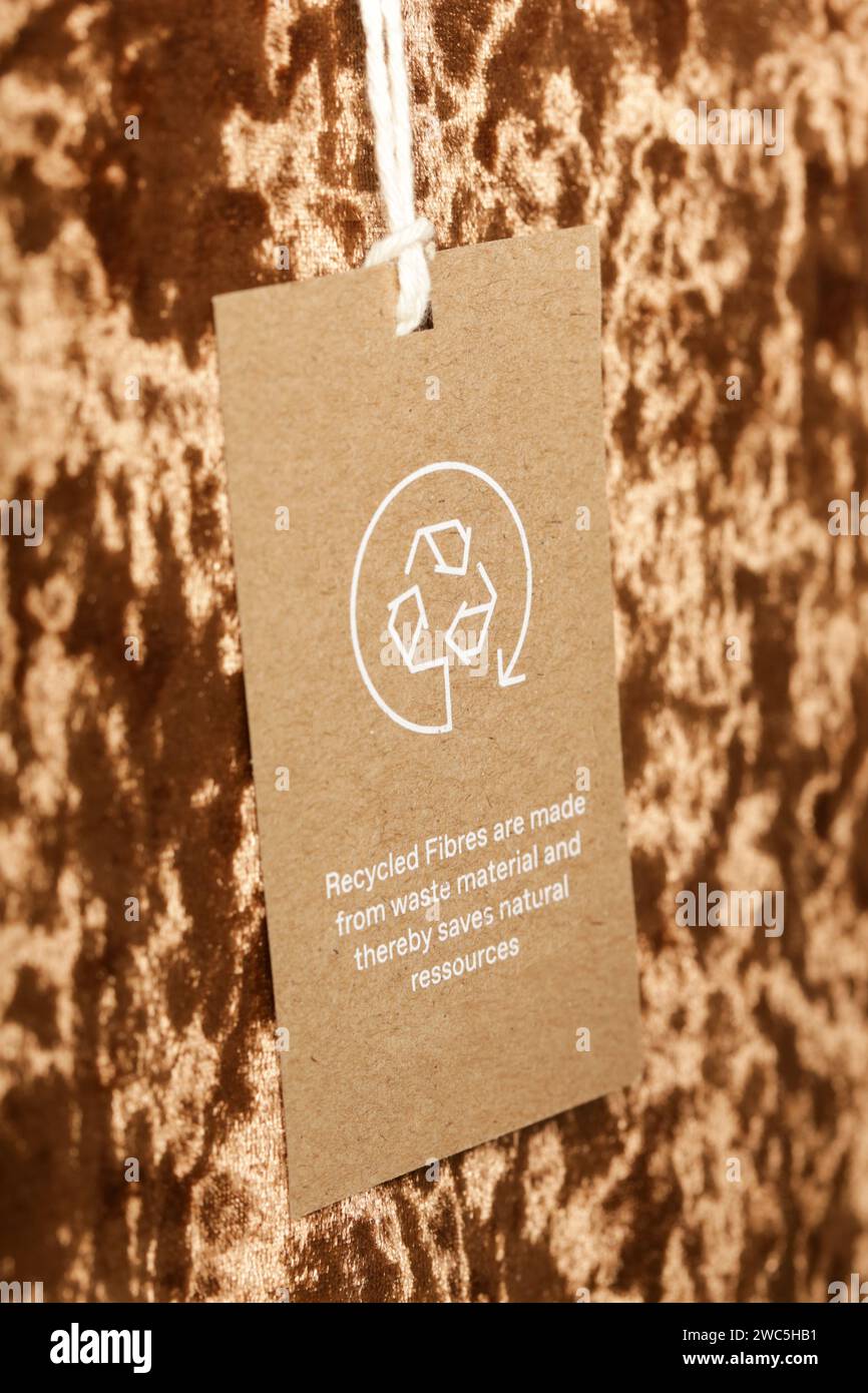 Close up of clothing tag with recycle icon. Recycling products concept ...