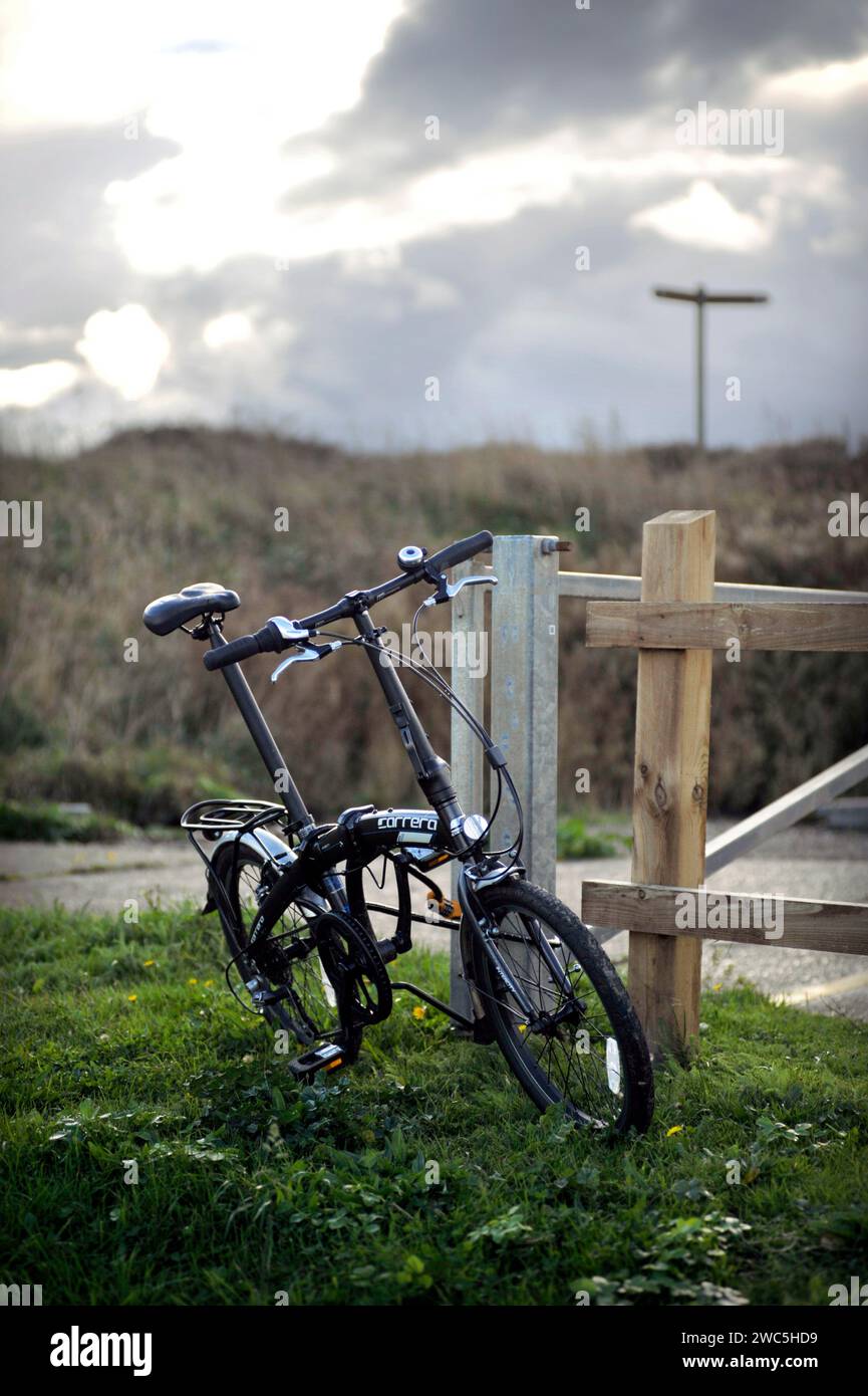 fold up push bike leaning away from wooden fence Stock Photo - Alamy