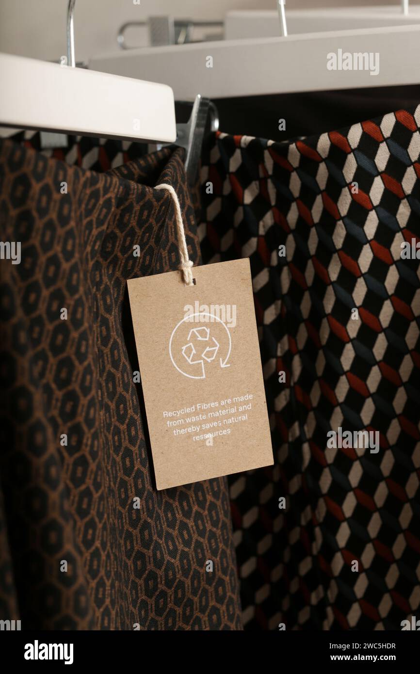 Close up of clothing tag with recycle icon. Recycling products concept ...