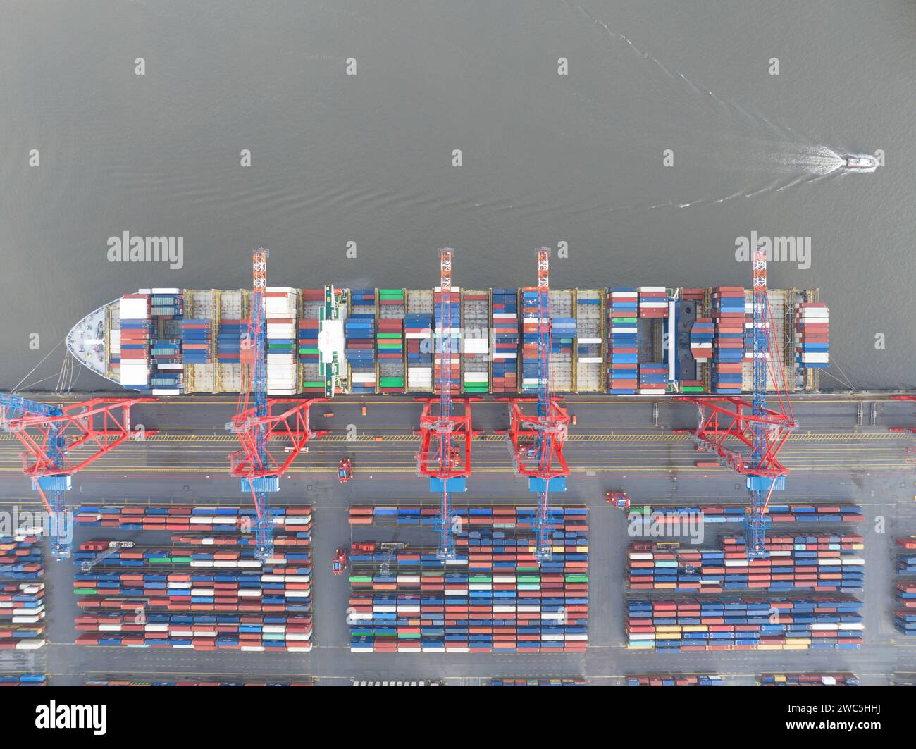 Birds eye aerial drone view on a container ship at the loading crane ...