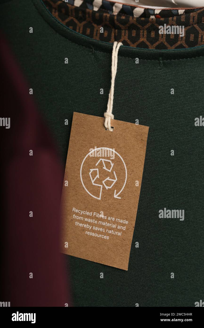 Close up of clothing tag with recycle icon. Recycling products concept ...