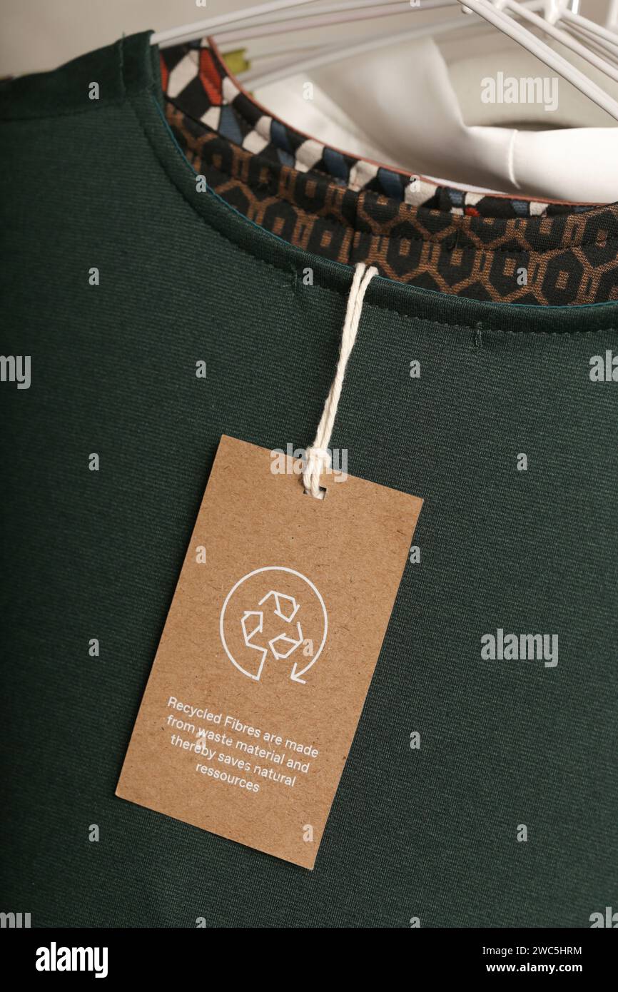 Close up of clothing tag with recycle icon. Recycling products concept ...