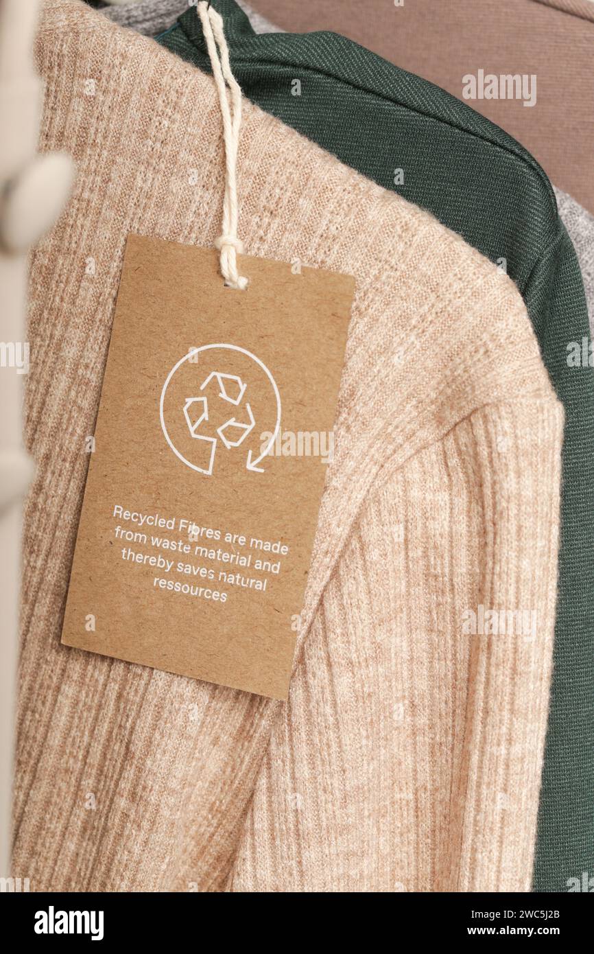 Close up of clothing tag with recycle icon. Recycling products concept ...