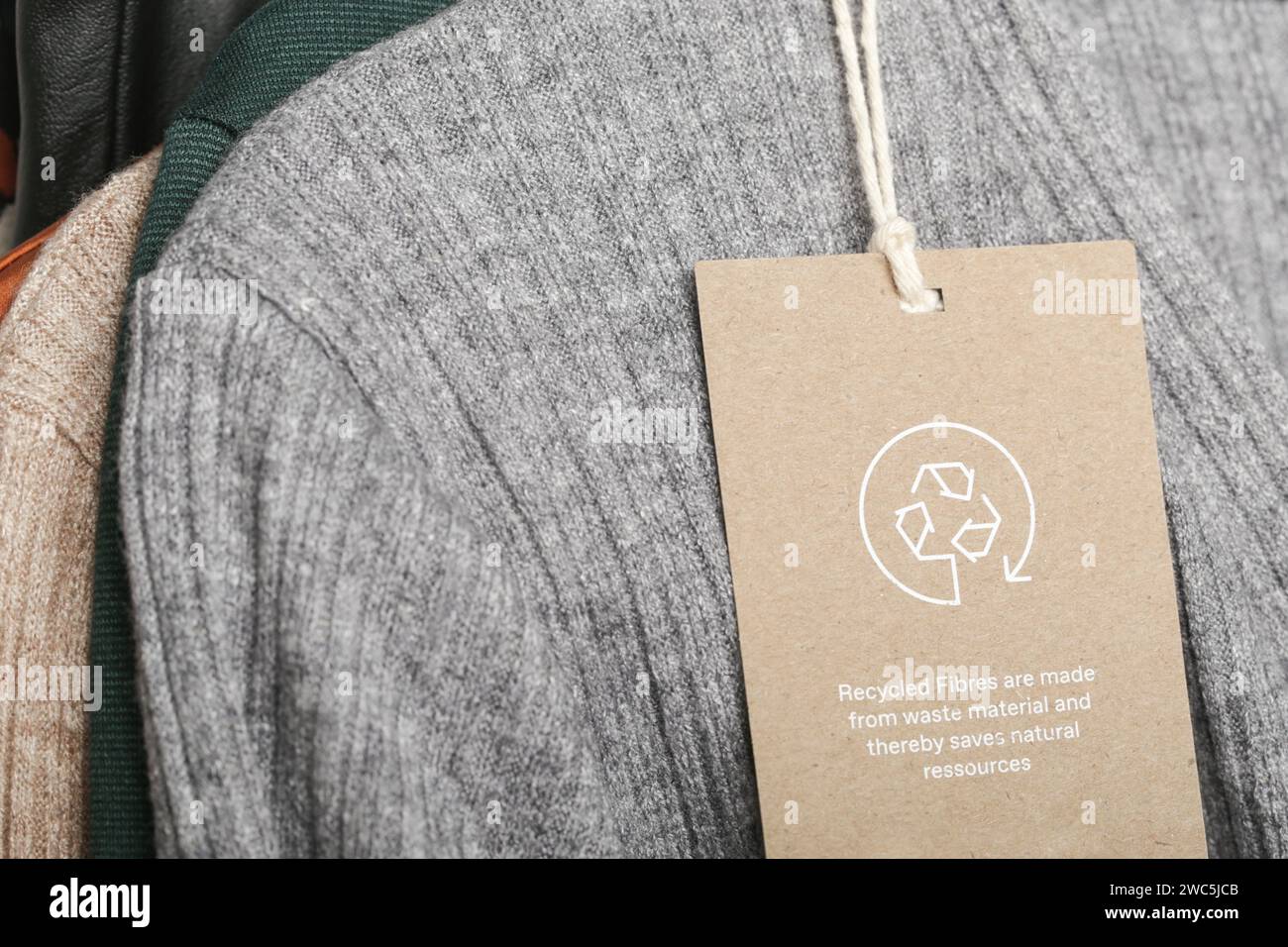 Close up of clothing tag with recycle icon. Recycling products concept ...