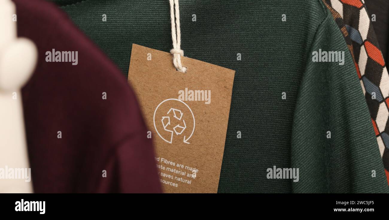 Close up of clothing tag with recycle icon. Recycling products concept ...