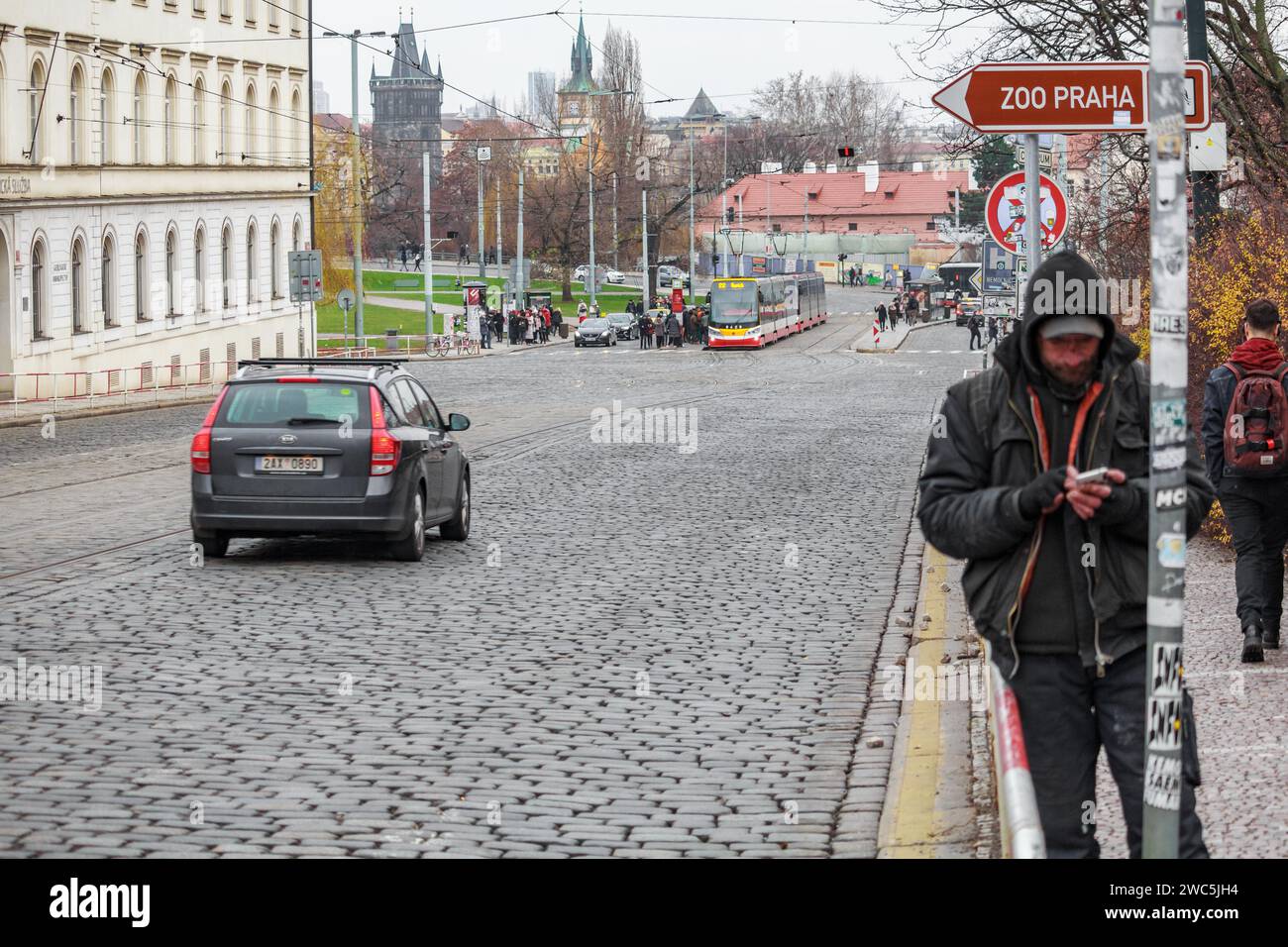 A homeless man with a phone on the street of the old historic medieval ...