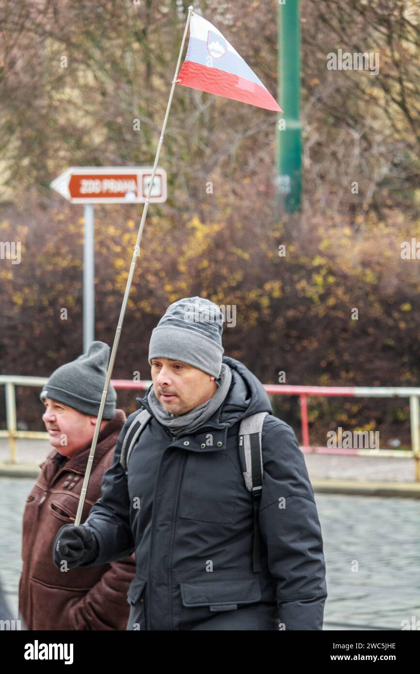 Photo of a tourist guide with warm winter clothes holding the slovenian ...