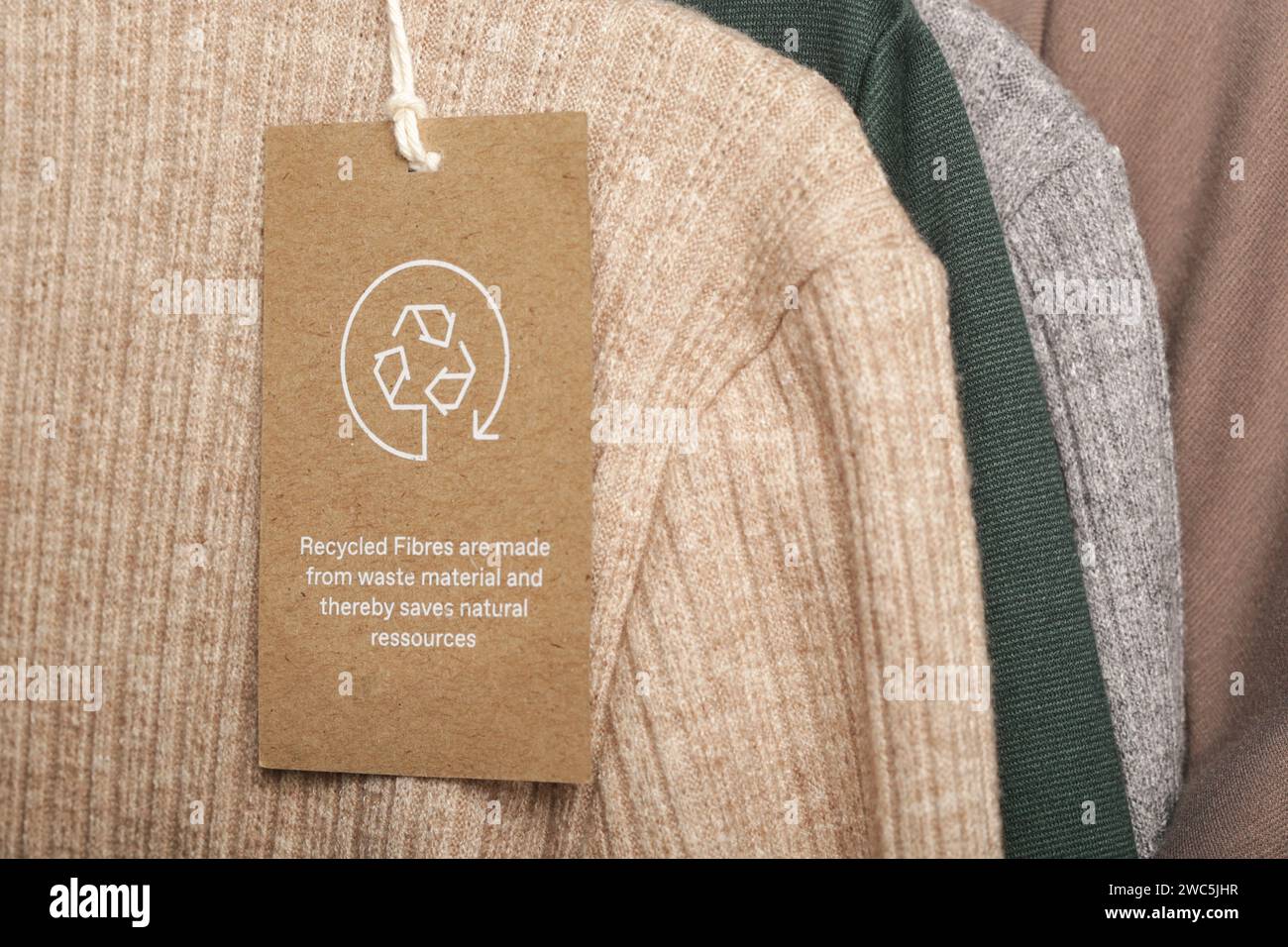 Close up of clothing tag with recycle icon. Recycling products concept ...