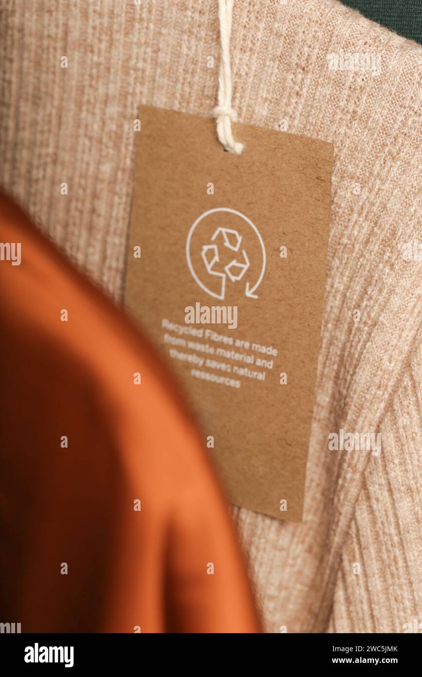 Close up of clothing tag with recycle icon. Recycling products concept ...