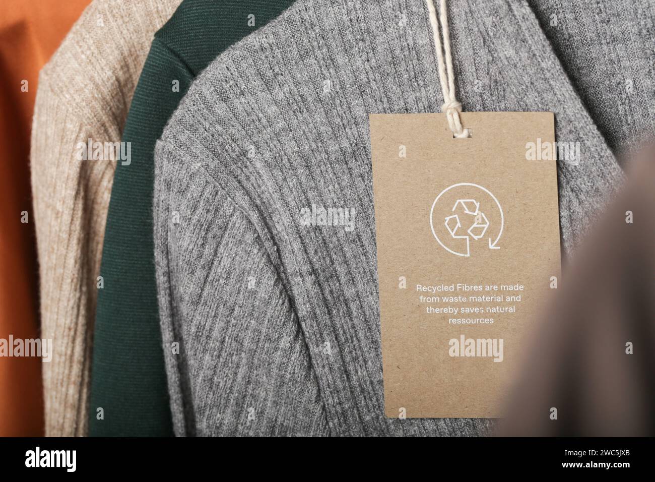 Close up of clothing tag with recycle icon. Recycling products concept ...