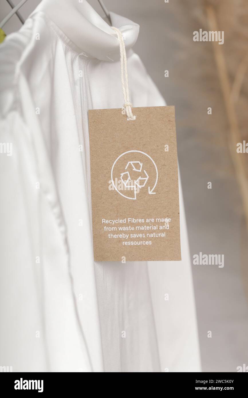 Close up of clothing tag with recycle icon. Recycling products concept ...