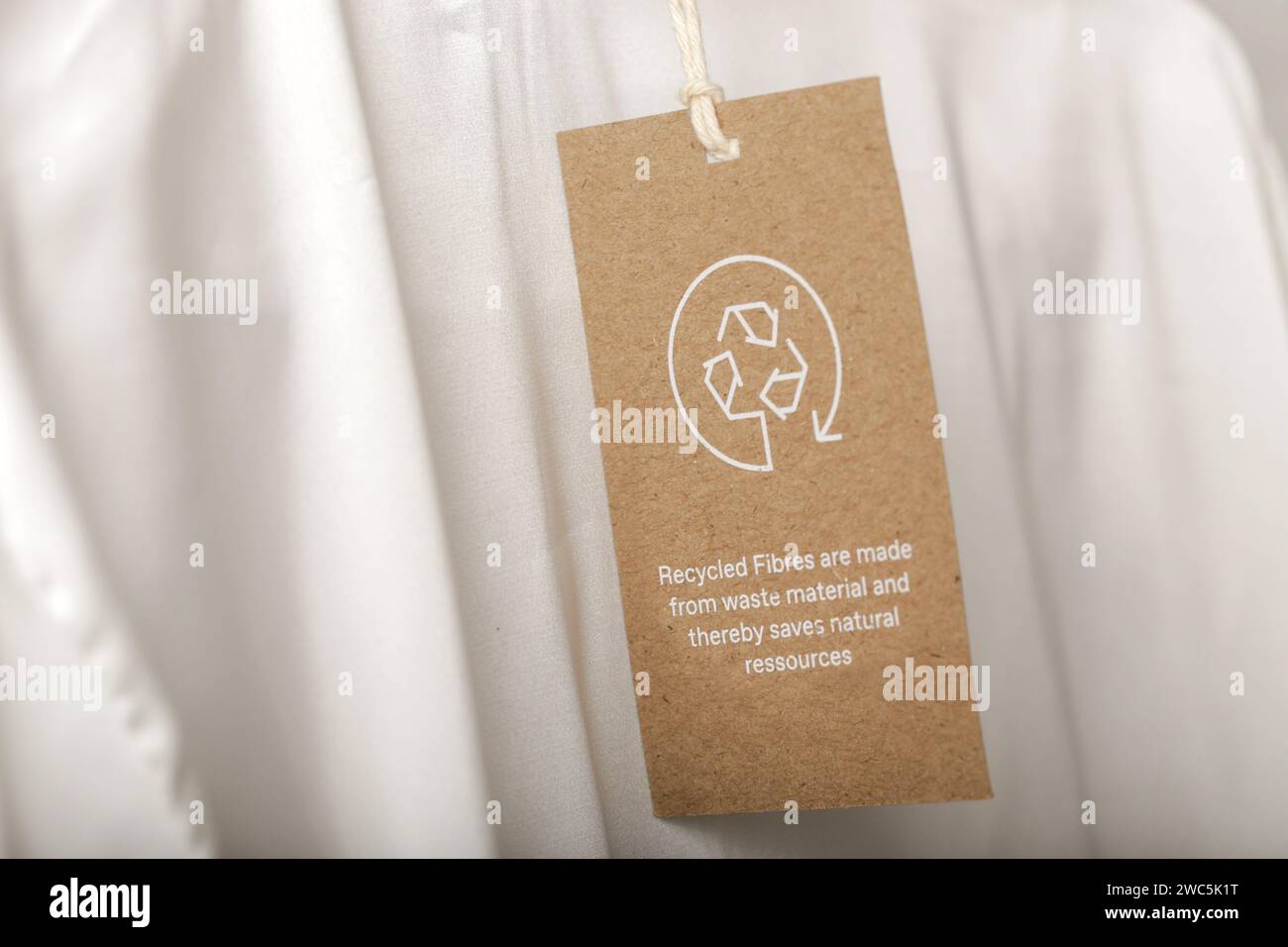 Close up of clothing tag with recycle icon. Recycling products concept ...