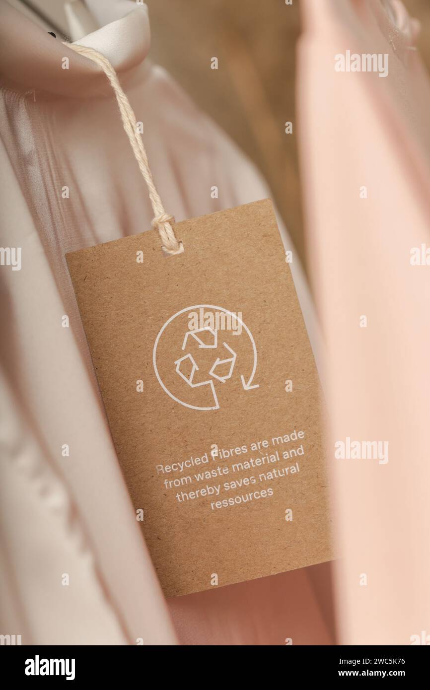 Close up of clothing tag with recycle icon. Recycling products concept ...