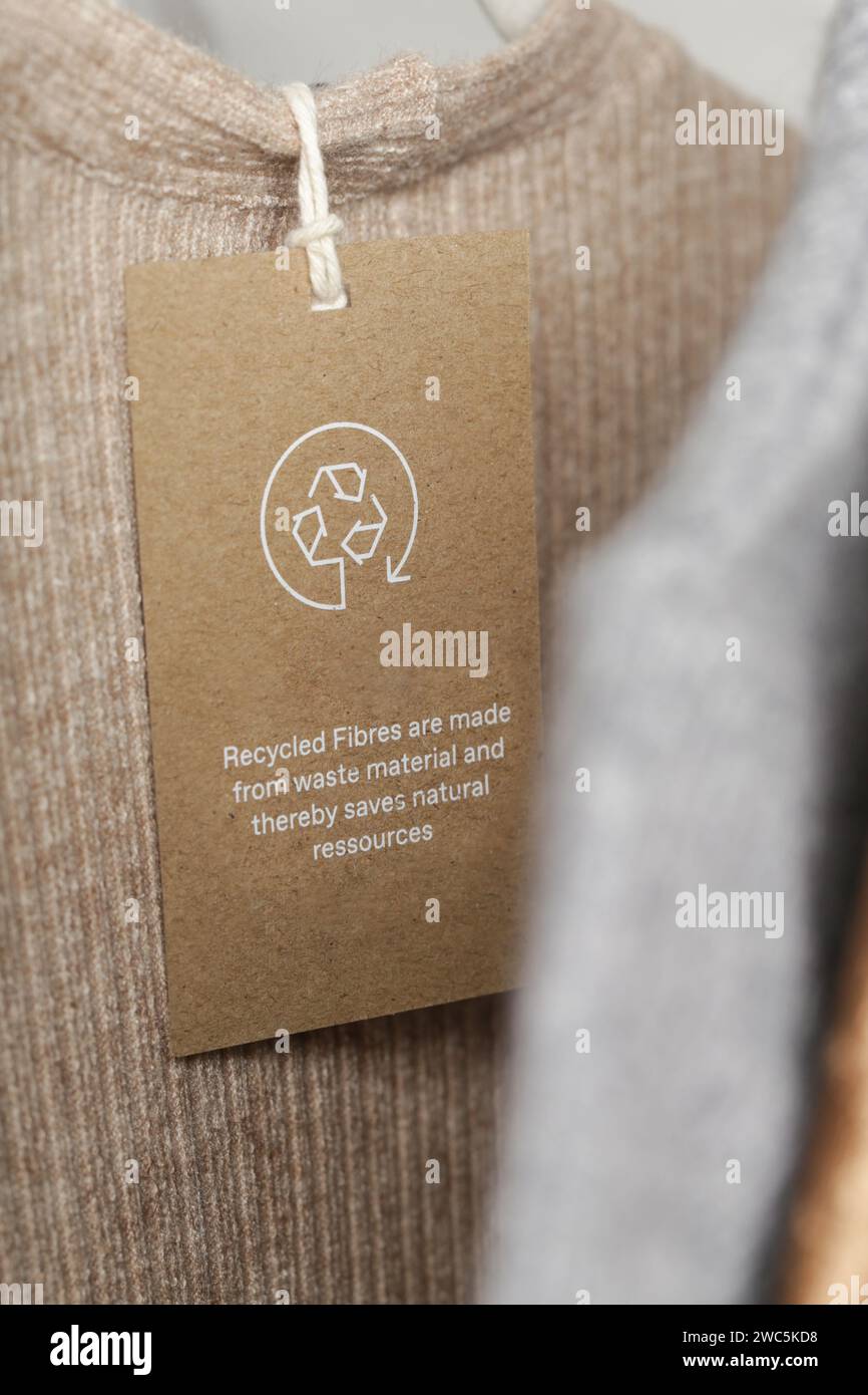 Close up of clothing tag with recycle icon. Recycling products concept ...