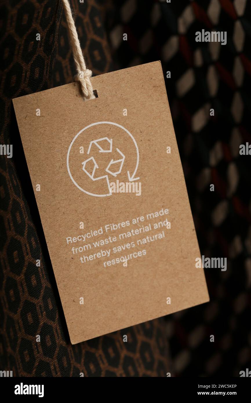 Close up of clothing tag with recycle icon. Recycling products concept ...