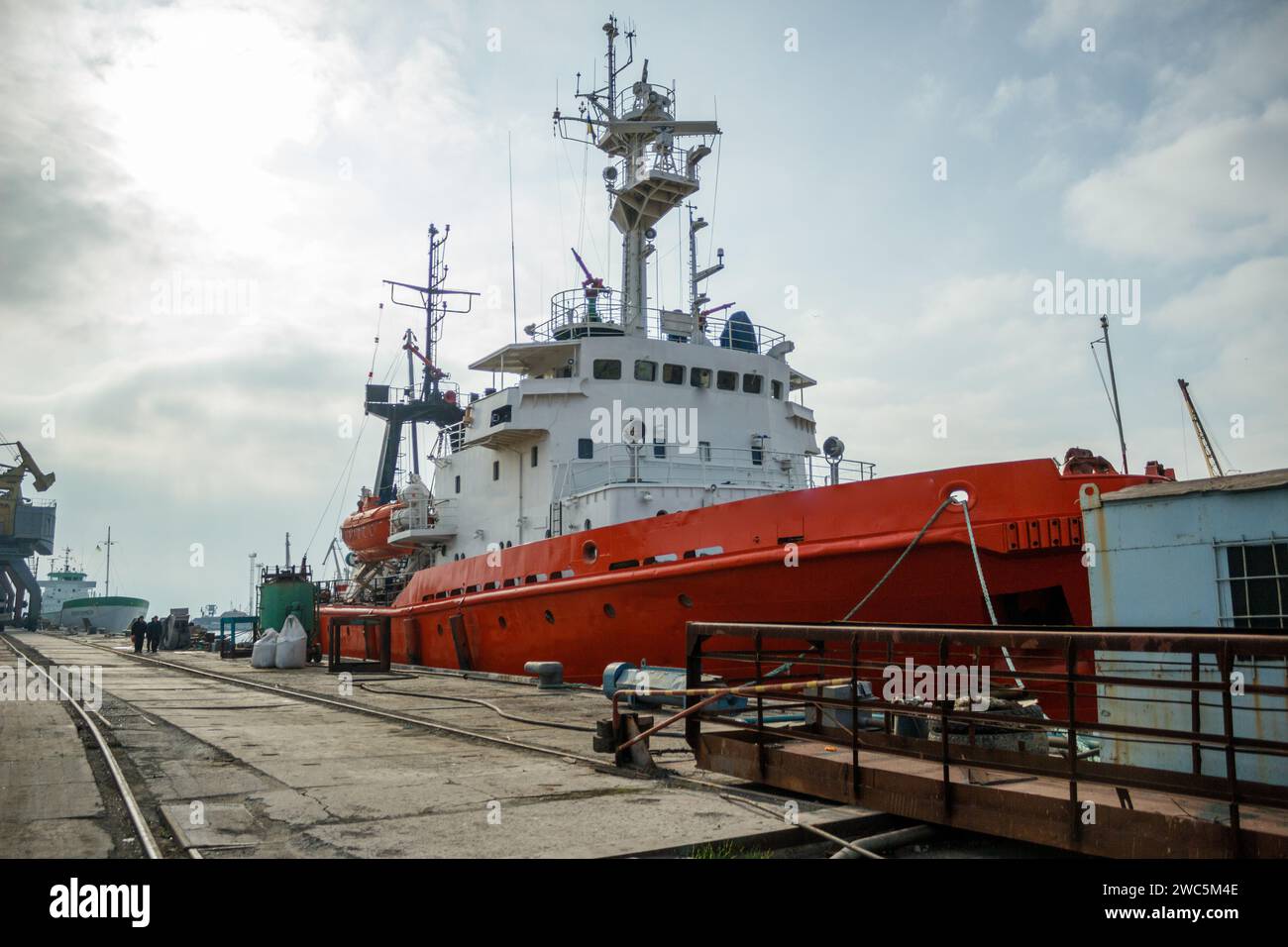Orange fishing vessel docked at port. Angling boat ready for maritime ...