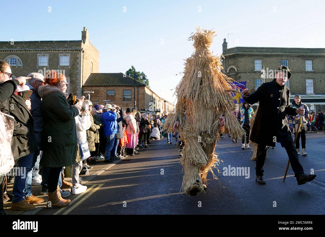 The Straw Bear is paraded through the streets accompanied by attendant ...