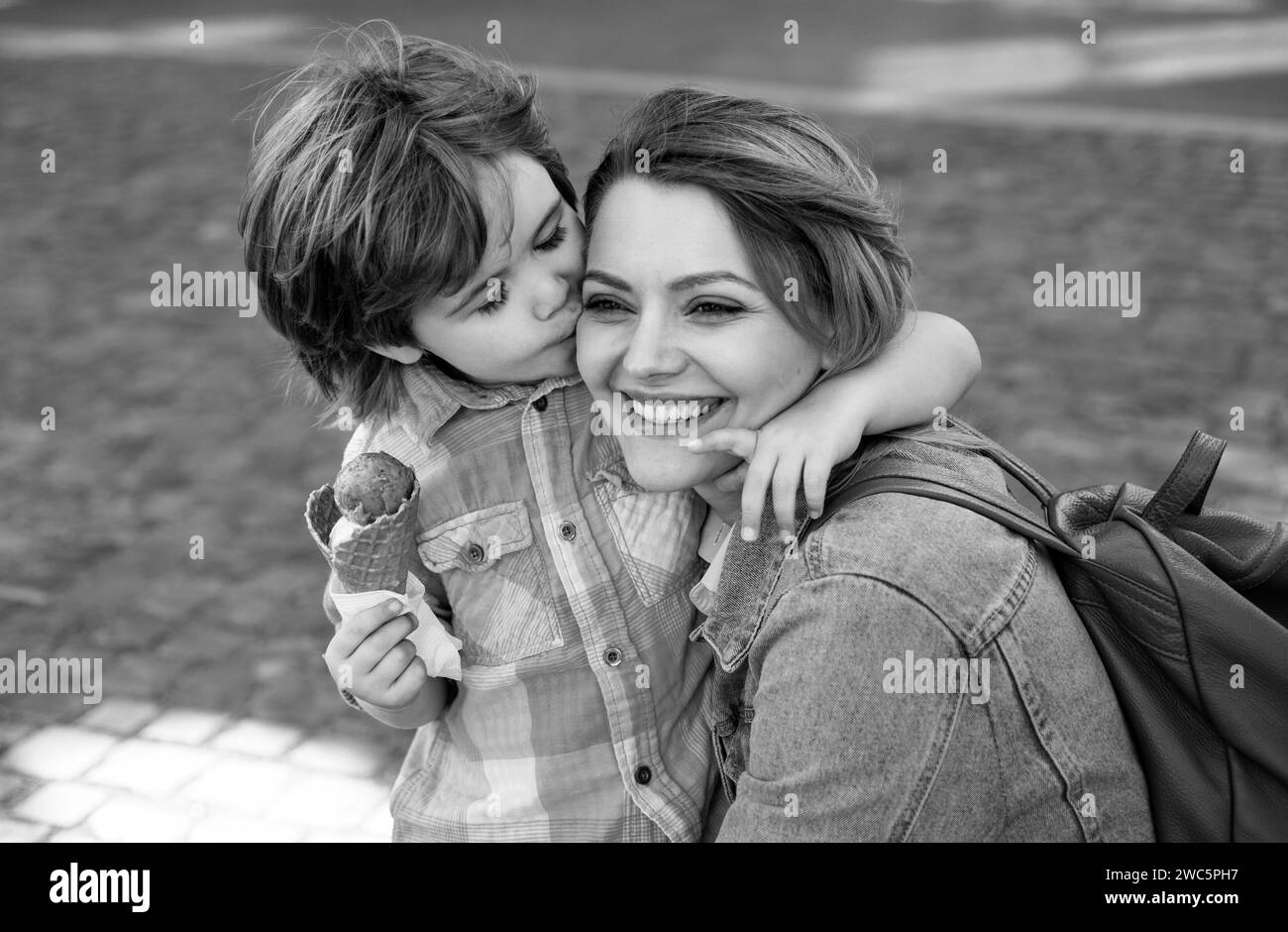 Mother and child eat icecream outdoor. Junk food. Delicious summer ice ...