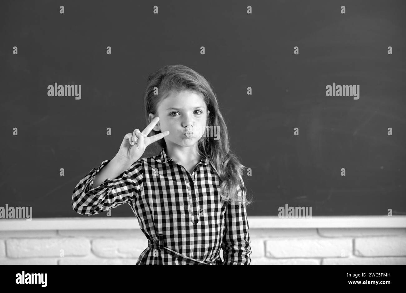 Funny child at school. Kid is learning in class on background of ...