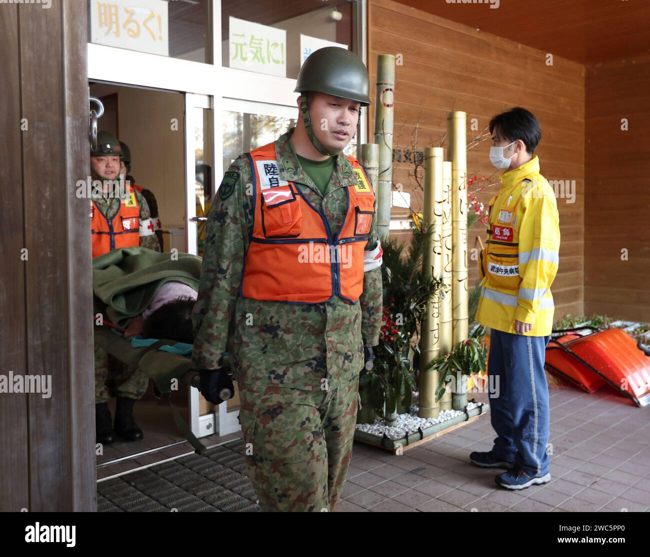 DMAT (Disaster Medical Assistance Team) and Japan Self-Defense Force members transport patients ...