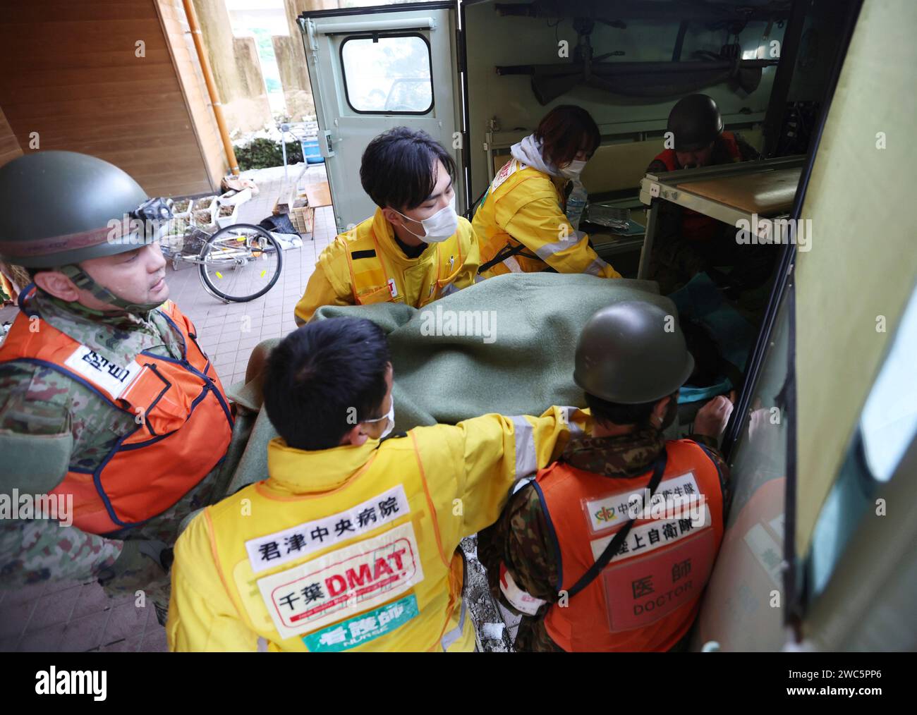 DMAT (Disaster Medical Assistance Team) and Japan Self-Defense Force members transport patients ...