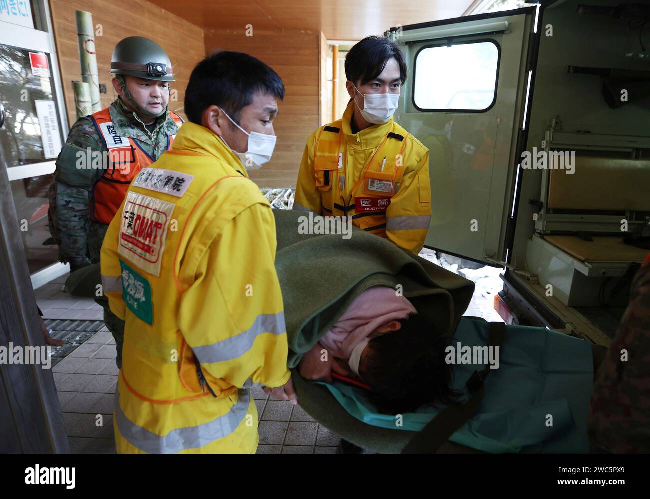 DMAT (Disaster Medical Assistance Team) and Japan Self-Defense Force members transport patients ...