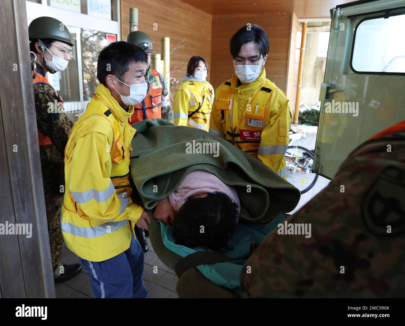 DMAT (Disaster Medical Assistance Team) and Japan Self-Defense Force members transport patients ...