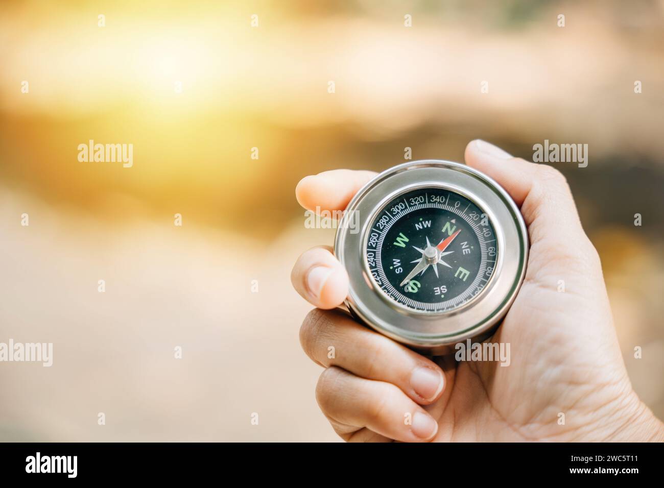 In the forest a hiker conquers confusion by holding a compass. The ...